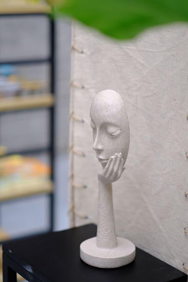 Vertical Shot of a Creative White Statue with a Hand Holding a Face ...