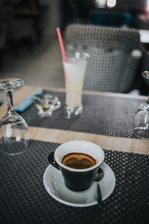 Vertical Shot of a Cup of Espresso on a Saucer on the Table in a Cafe ...