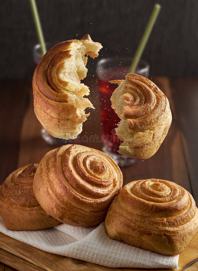 Vertical Shot of Cut Cinnamon Buns Falling on a Board on the Table ...