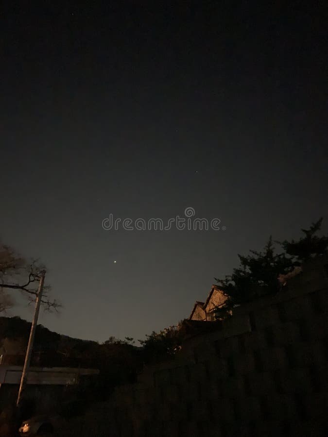 Vertical Shot of a Dark Night Sky Over Illuminated Houses Stock Photo ...