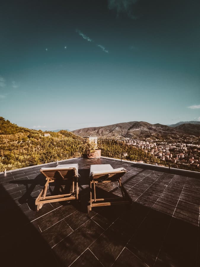 Vertical Shot of Deck Chairs at the Balcony with a Beautiful View of ...