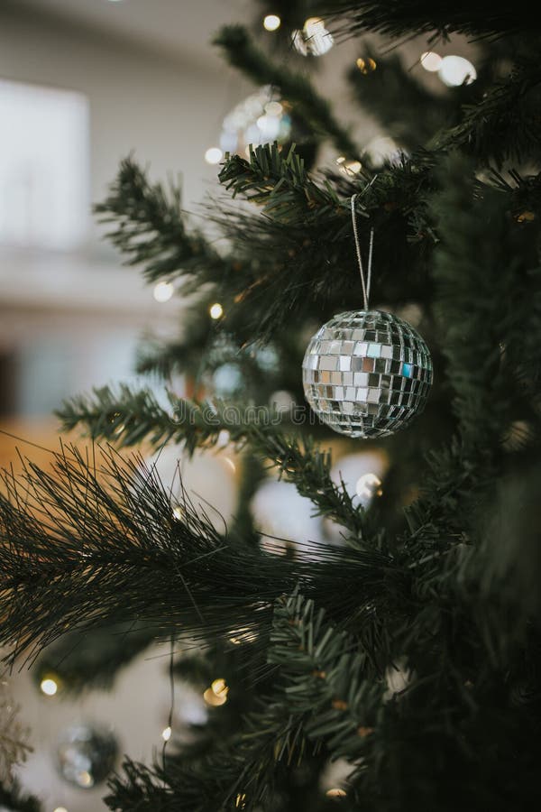Vertical Shot of a Disco Ball Ornament Hanging on a Christmas Tree ...
