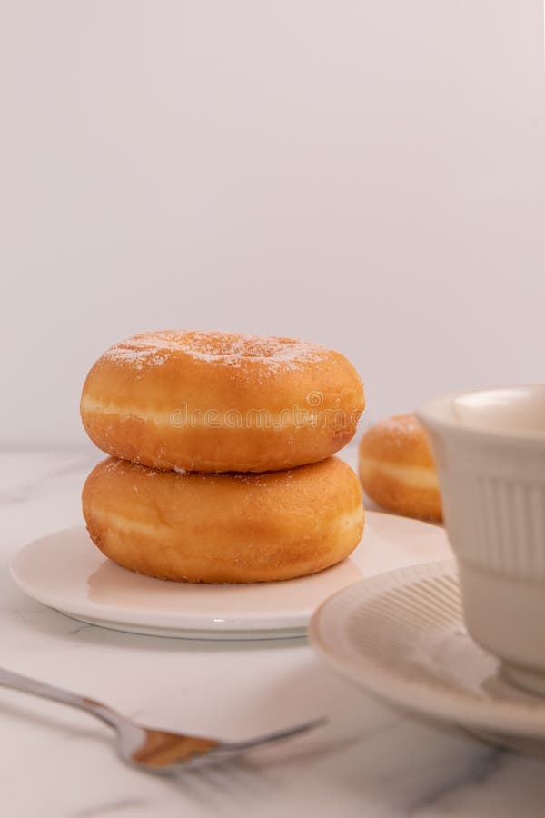Vertical Shot of Donuts Served with Coffee on a White Table Stock Photo ...