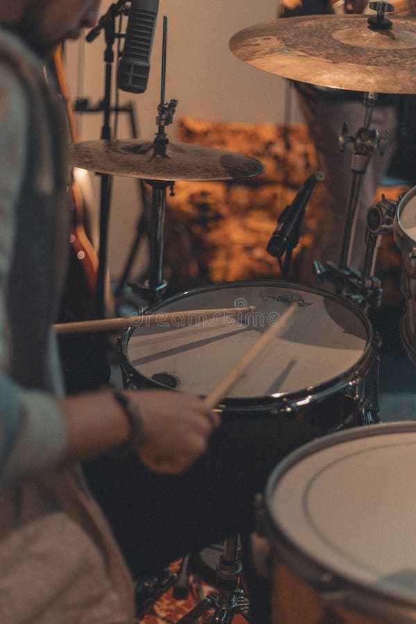 Vertical Shot of Drum Kit with a Male Playing Them Stock Photo - Image ...
