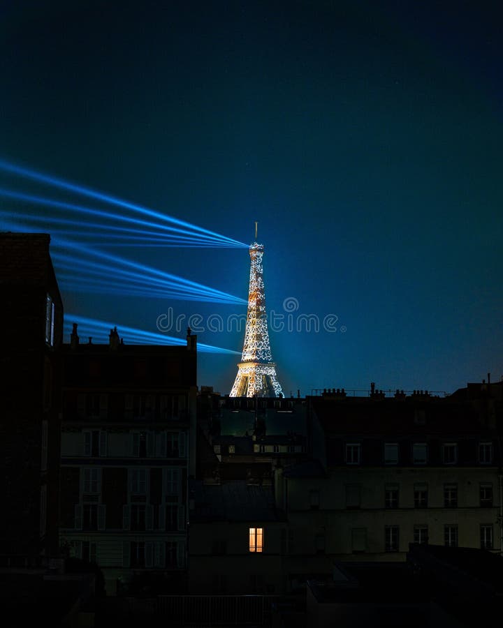Vertical Shot of the Eiffel Tower Beaming Blue Lights in the Night Sky ...
