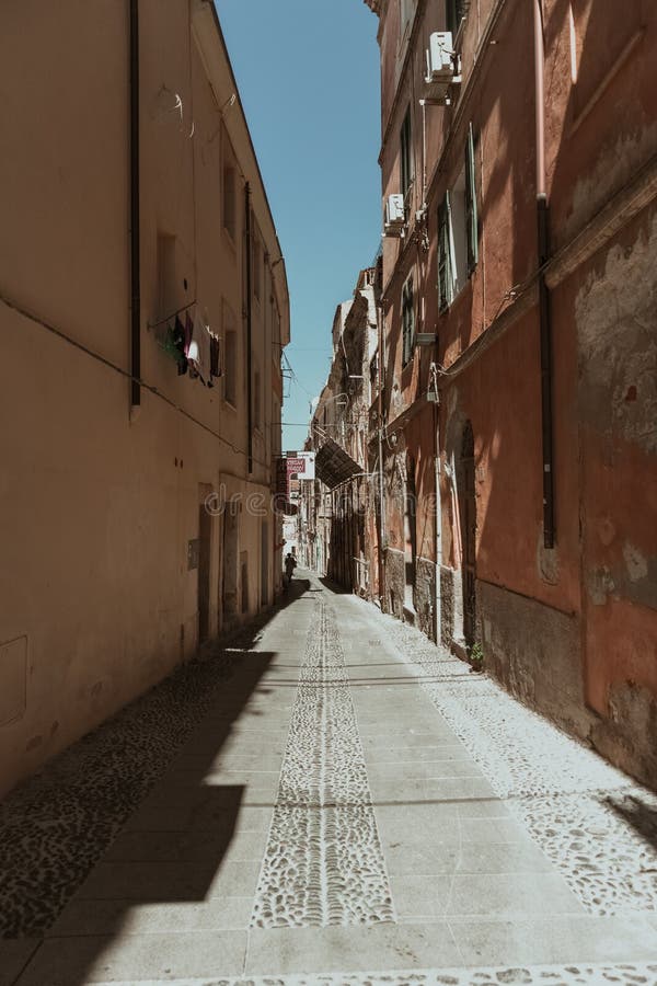 Vertical Shot of an Empty Alleyway in the Middle of Buildings Under a ...