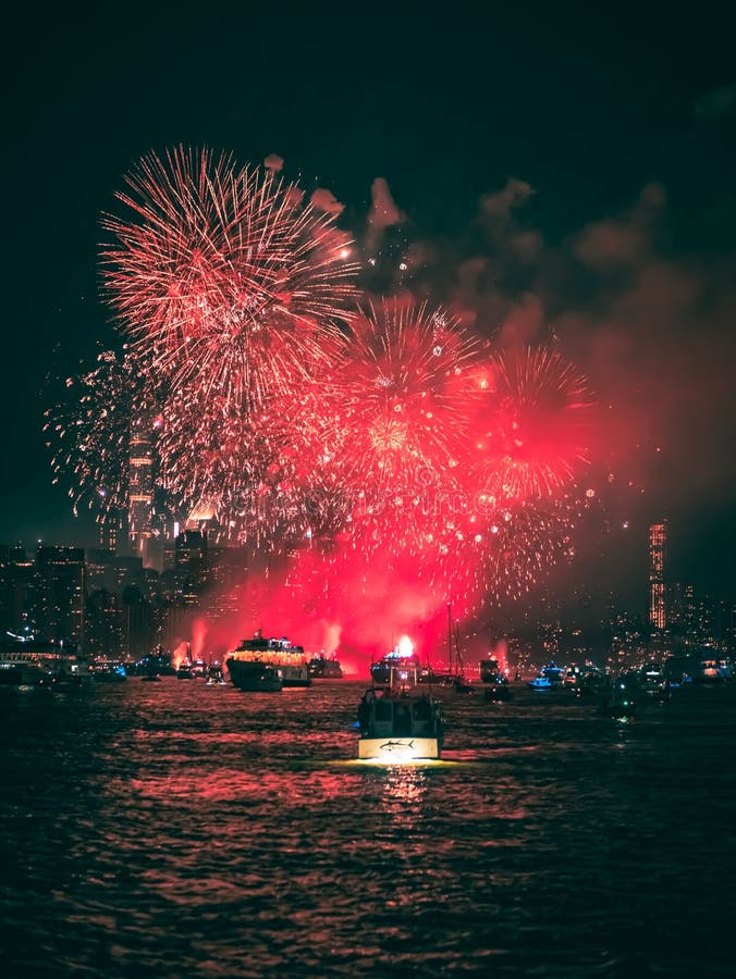 Vertical Shot of Exploding Bright Red July 4th Fireworks Over Water ...