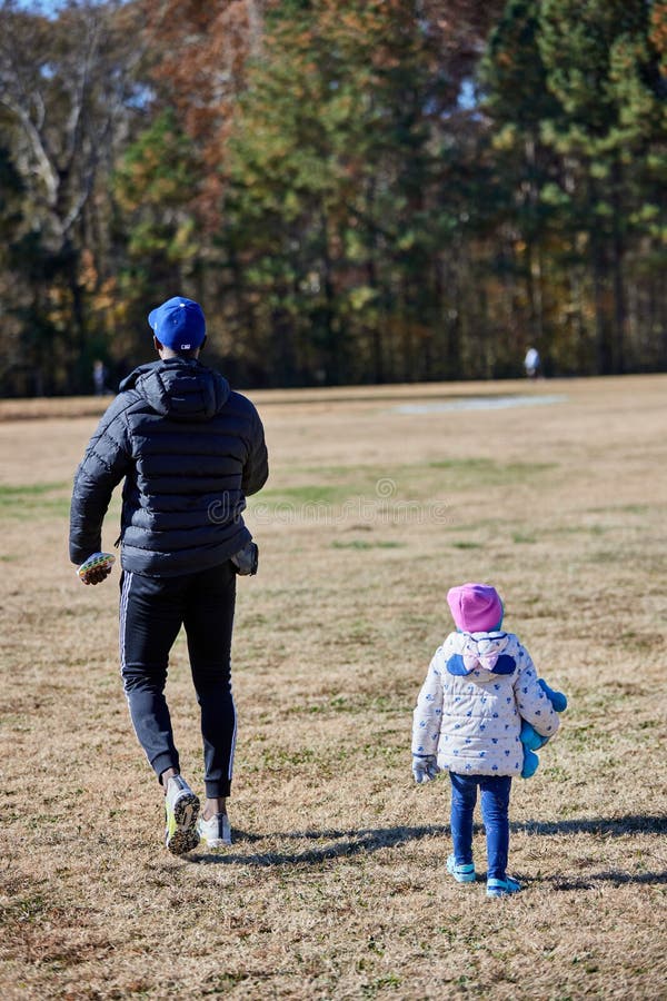 Vertical Shot of a Father with the Daughter Walking in the Park - Shot ...