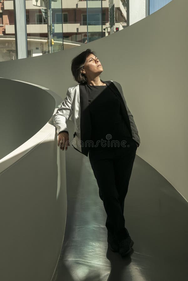 Vertical Shot of a Female Leaning on the Wall of a Modern Building ...