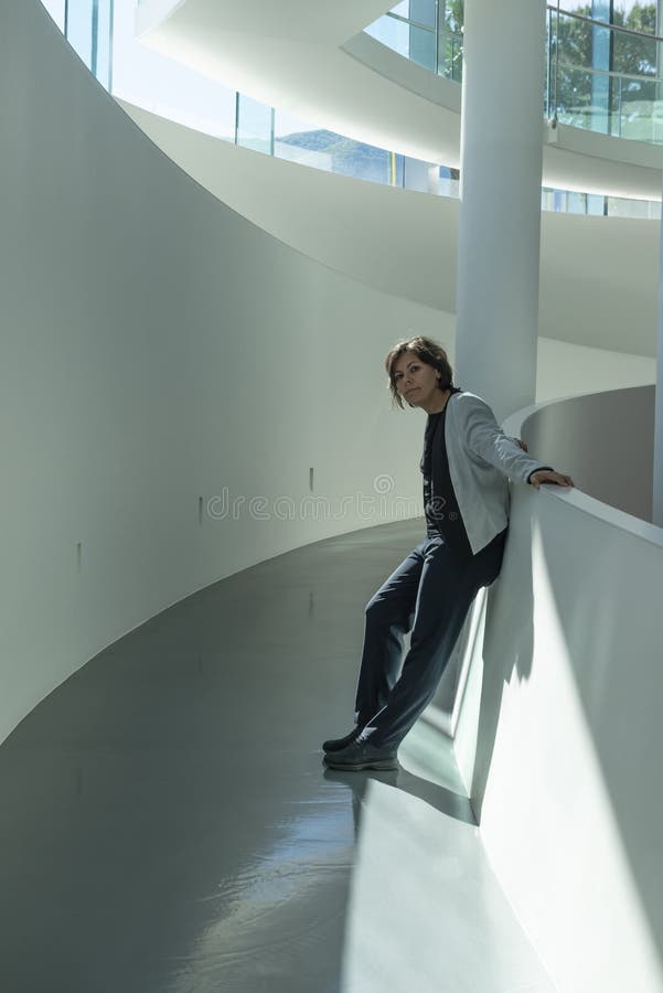 Vertical Shot of a Female Standing in a White Hallway Inside a White ...