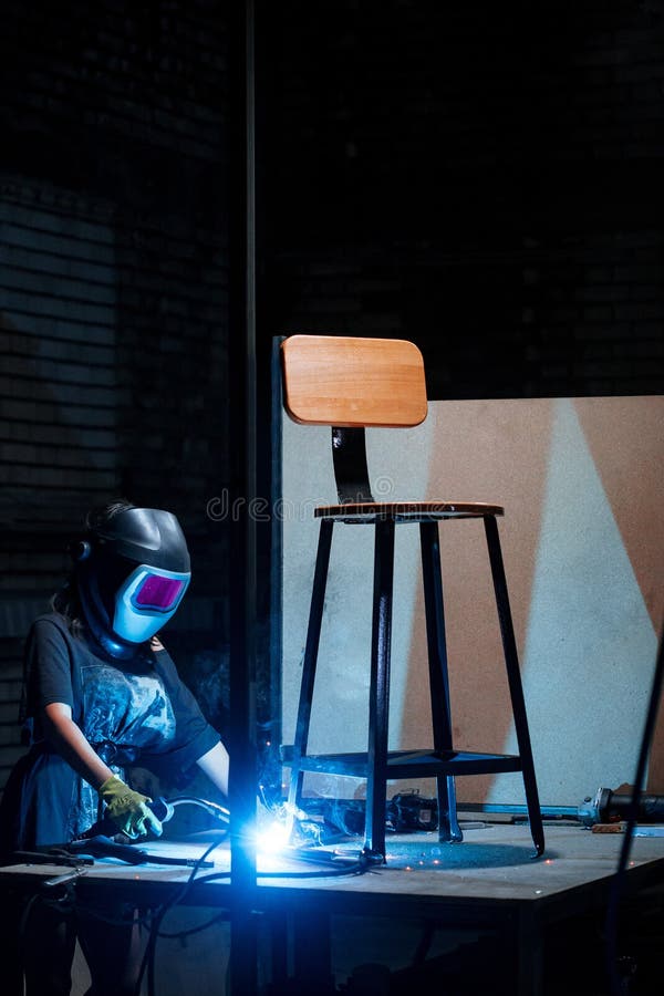 Vertical Shot of a Female Worker Welding the Legs of a Stool Stock ...