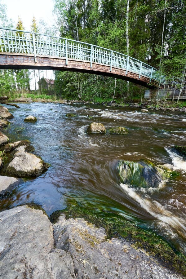 Vertical Shot of a Footbridge Across a Rocky River Stock Image - Image ...