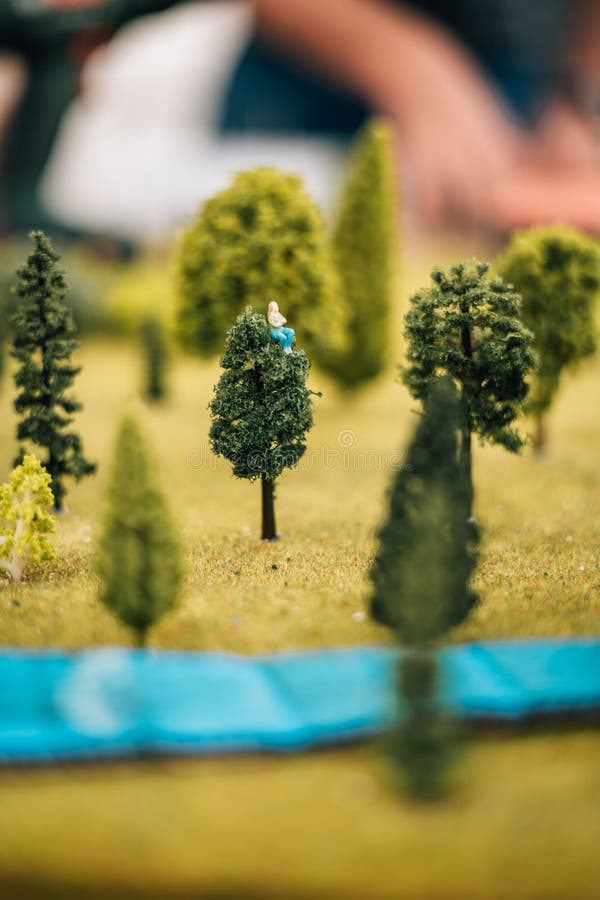 Vertical Shot of a Forest and a Tree Layout with a Girl Sitting on it ...