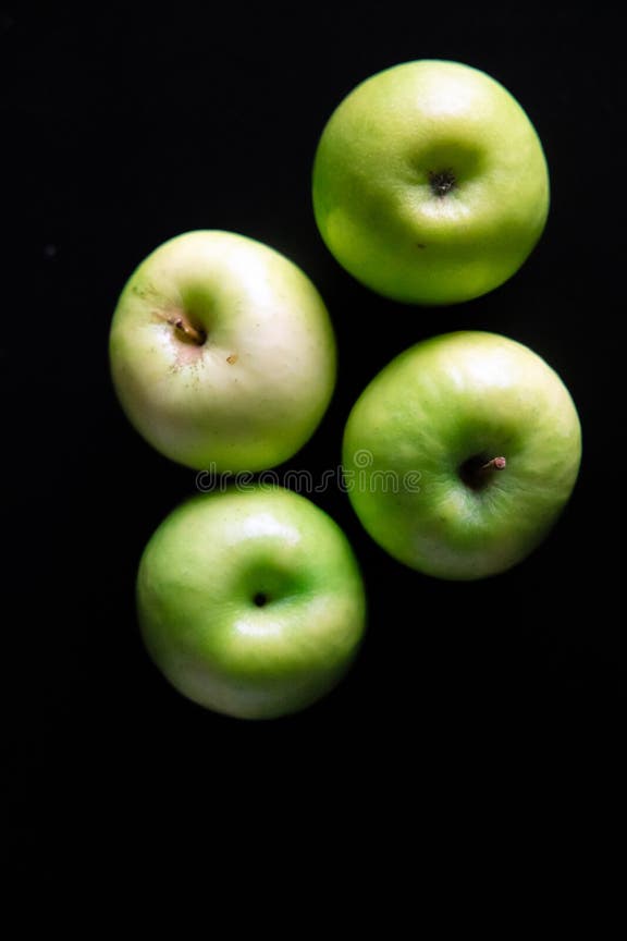 Vertical Shot of Four Green Apples on a Dark Surface Stock Photo ...