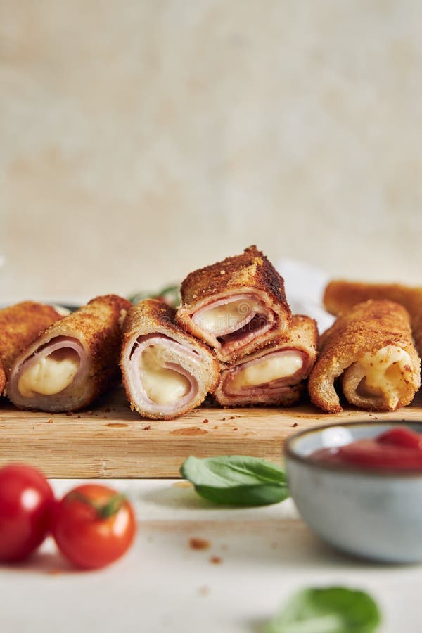 Vertical Shot of Fried Ham and Cheese Toast Rolls on a Board on the Ta ...
