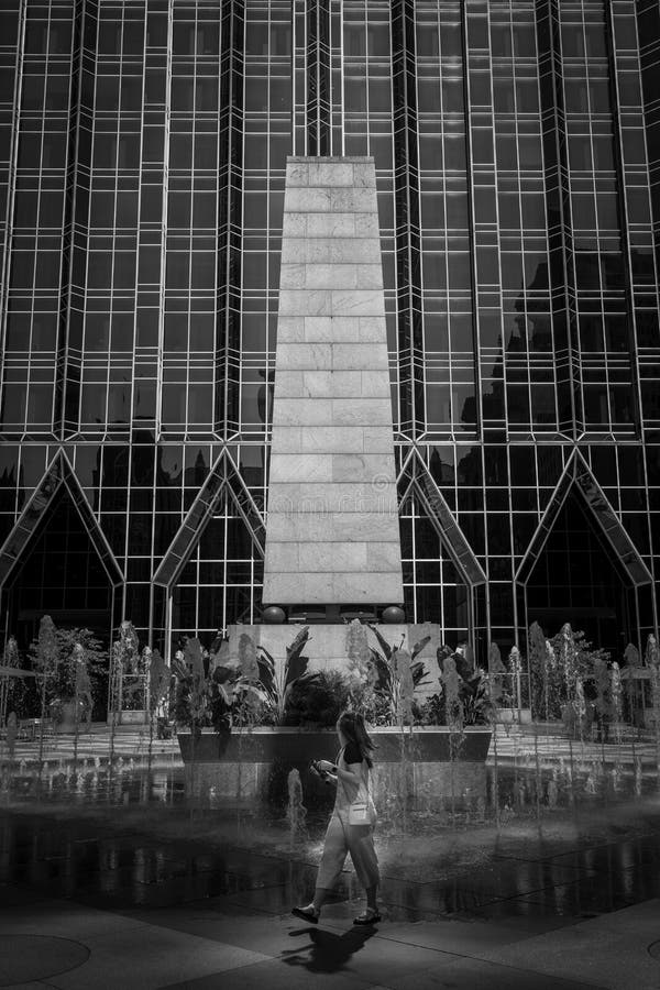 Vertical Shot Of A Girl Walking On The Square Of The Glassy Building Of One Ppg Place