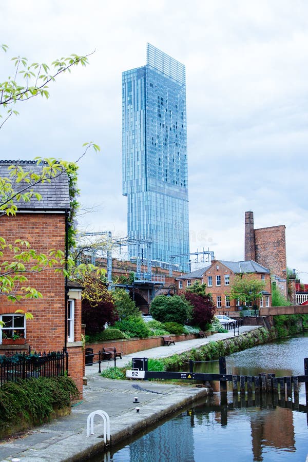 Vertical Shot of a Glass Skyscraper and Small Brick Houses Stock Image ...