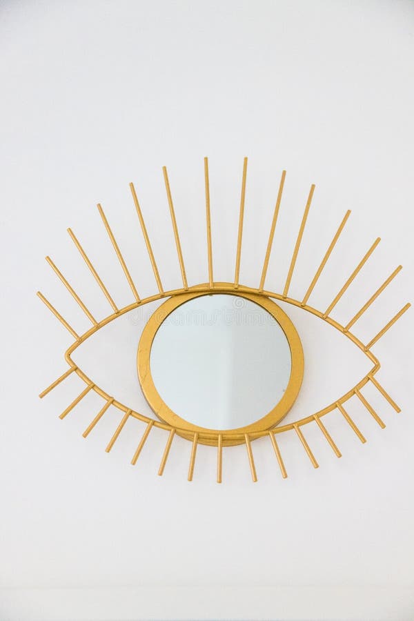 Vertical Shot of a Gold Mirror Shaped Like an Eye on a White Wall Stock ...