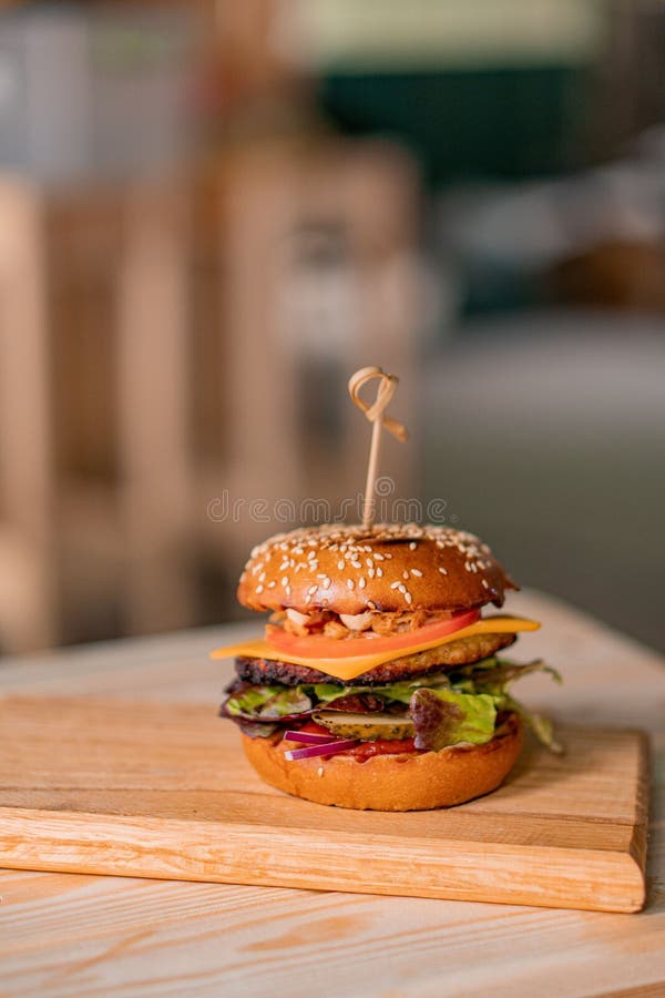 Vertical Shot of a Ground Chicken Burger on a Wooden Board on the Table ...