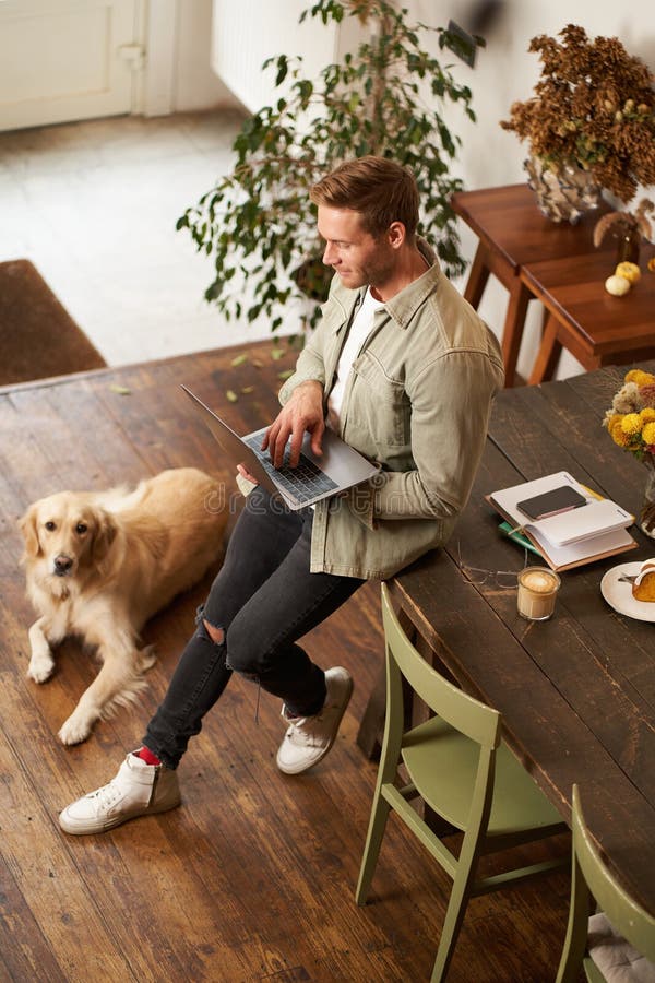 Vertical Shot of Handsome Young Man with a Dog, Leaning on Table ...