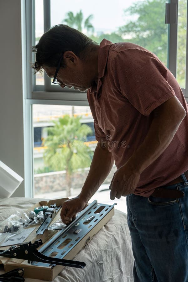 Vertical Shot of a Handyman Using a Screwdriver To Fix the TV Stock ...