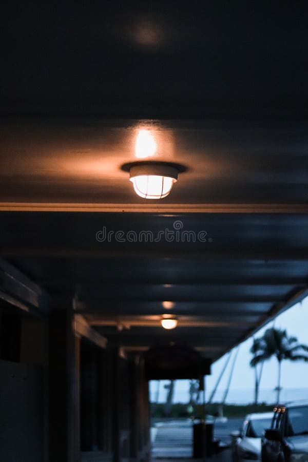 Vertical Shot of an Illuminated Light Bulb Over a Walkway Outdoors ...