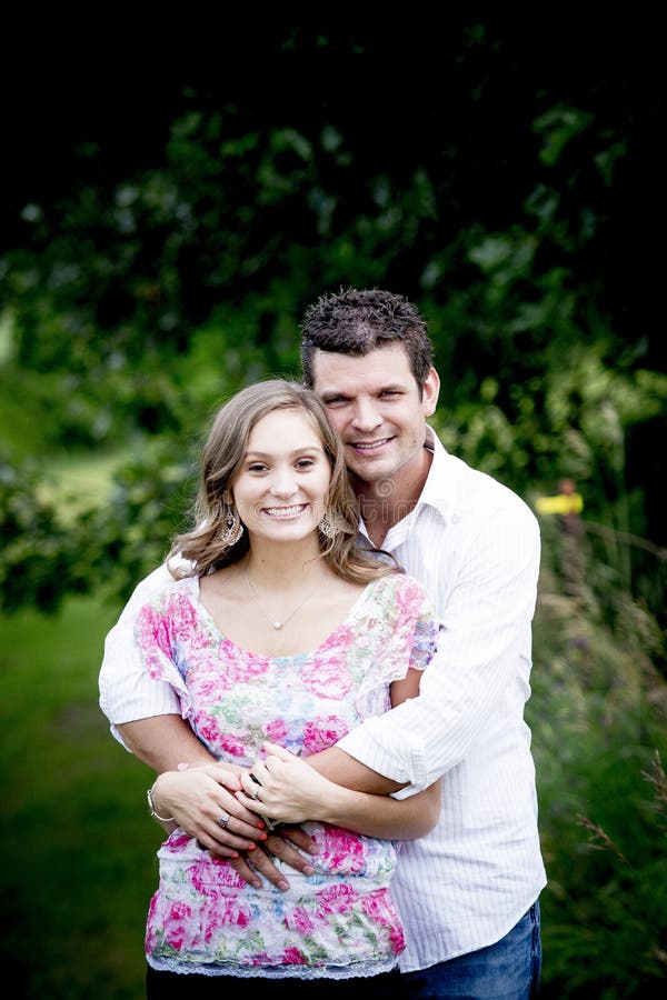 Vertical Shot of a Joyful Couple Hugging and Smiling at the Camera ...
