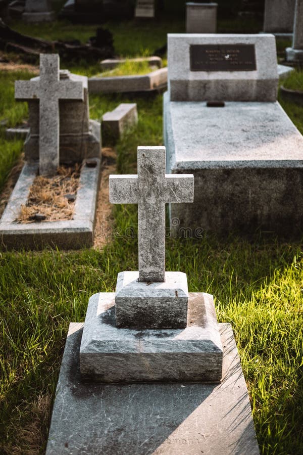 Vertical Shot of a Large White Stone Cross Situated in a Cemetery ...