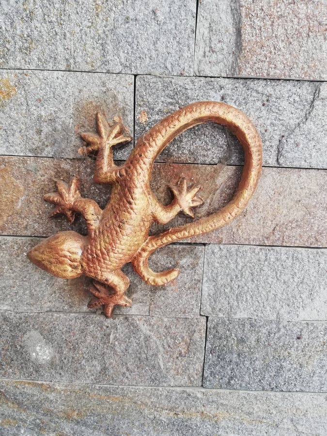 Vertical Shot of a Lizard Statue Painted Copper Color on a Stone ...