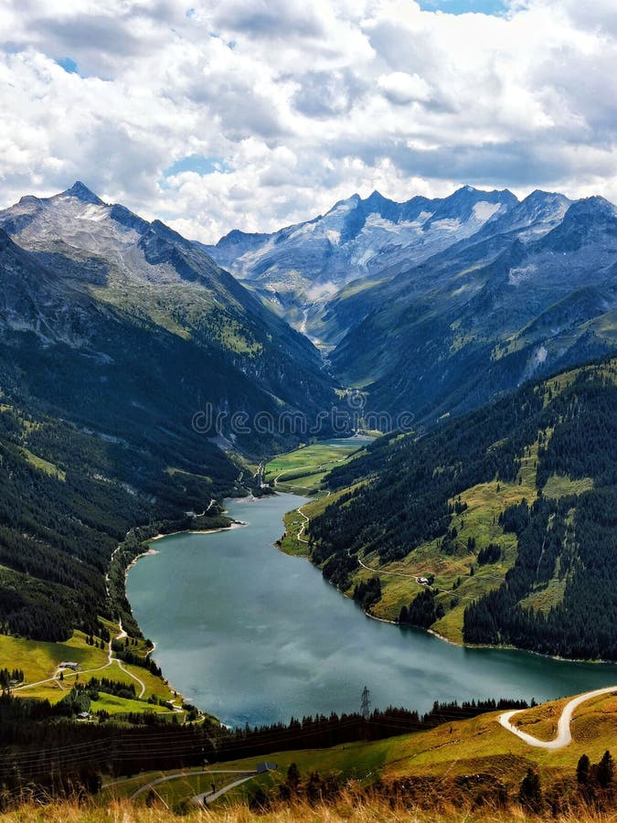 Vertical Shot of a Majestic Alpine Landscape with a River Flowing ...