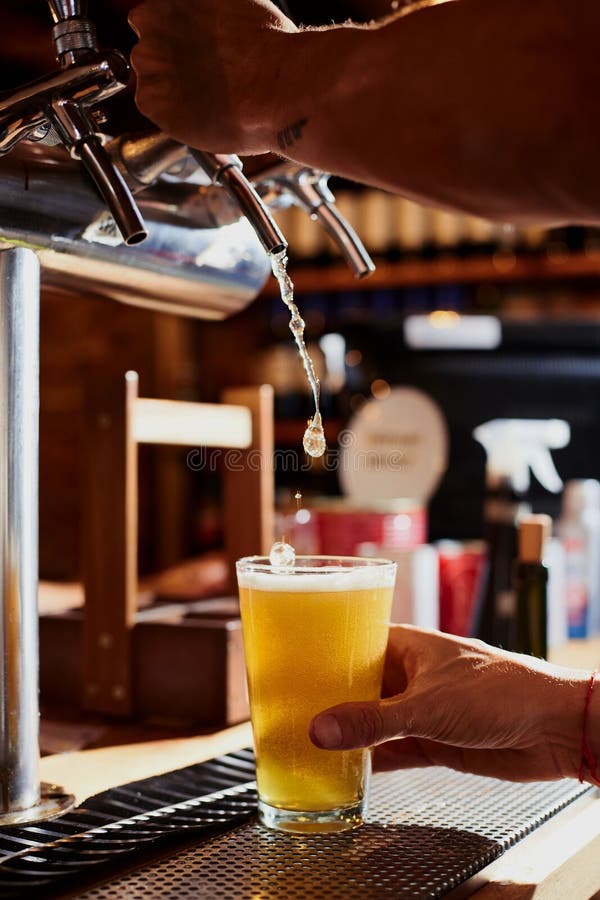 Vertical Shot of a Man Drafting a Beer at a Bar Stock Photo - Image of ...