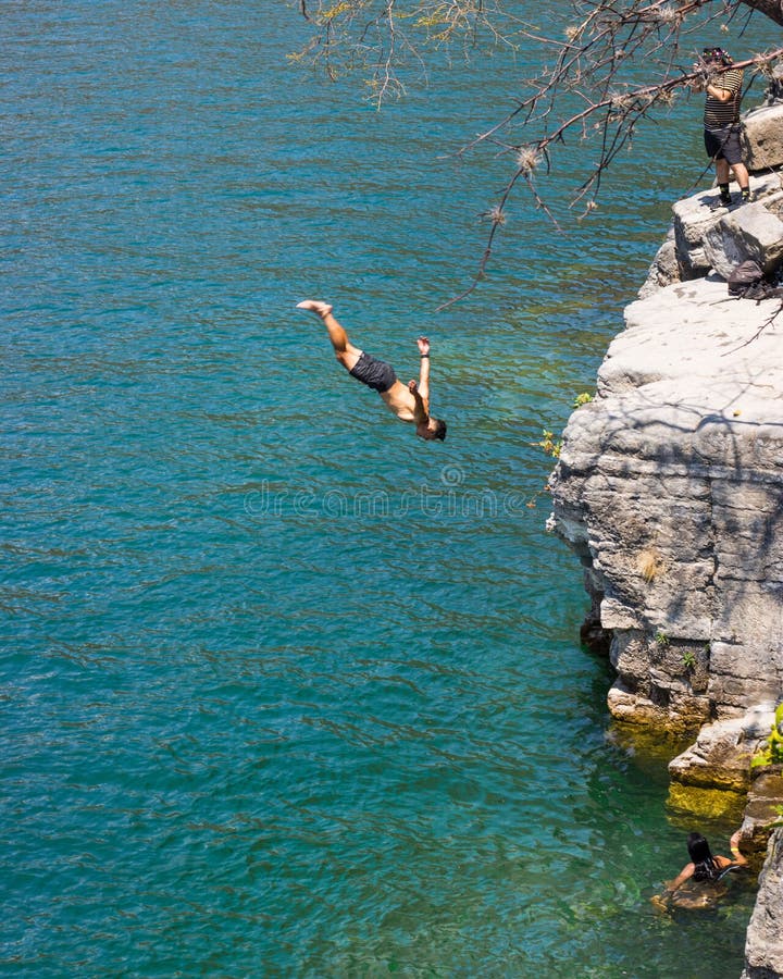 Vertical Shot of a Man Jumping into the Water. Stock Photo - Image of ...