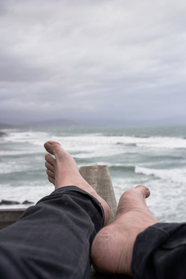 Vertical Shot of a Man S Feet in Front of the Beach Under a Clouded Sky ...
