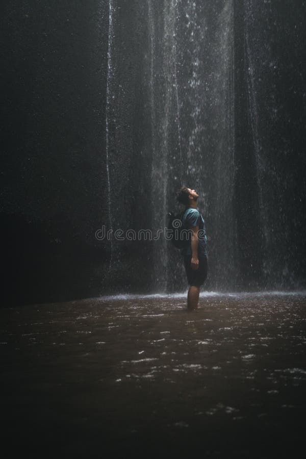 Vertical Shot of a Man Standing Under a Waterfall Stock Photo - Image ... Vertical Shot of a Man Standing Under a Waterfall Stock Photo - Image ...