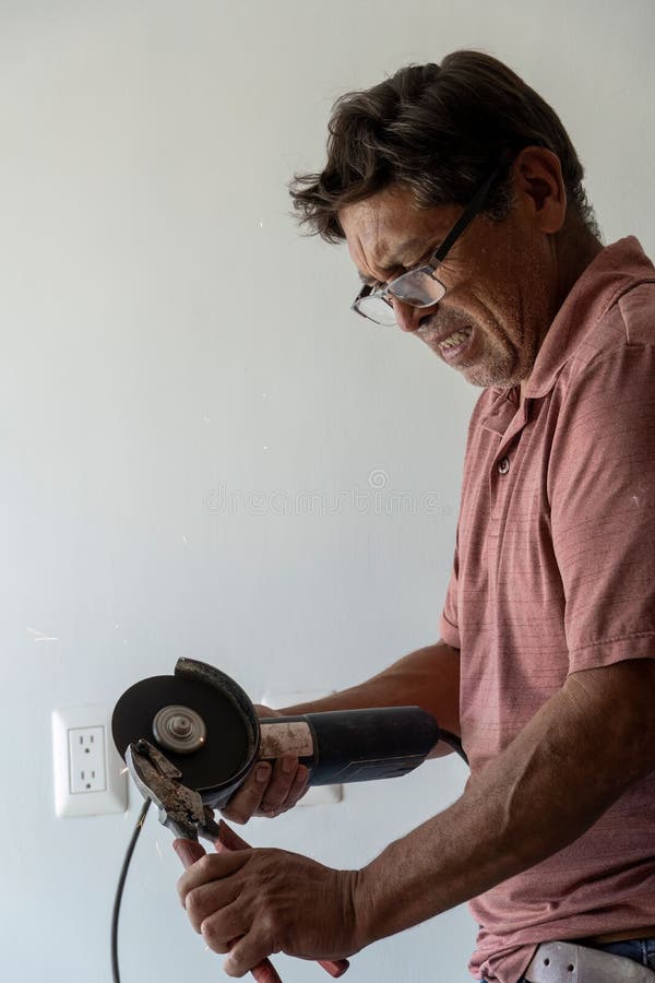 Vertical Shot of a Man Using Angle Grinder, Cutting a Screw, Friction ...