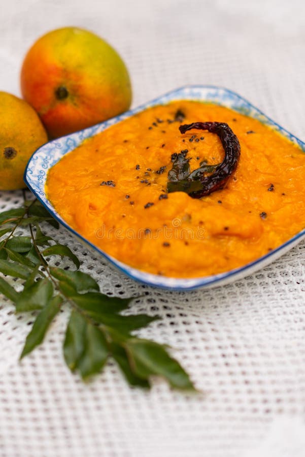 Vertical Shot of Mango Chutney on a Plate Surrounded by Mango Fruits ...
