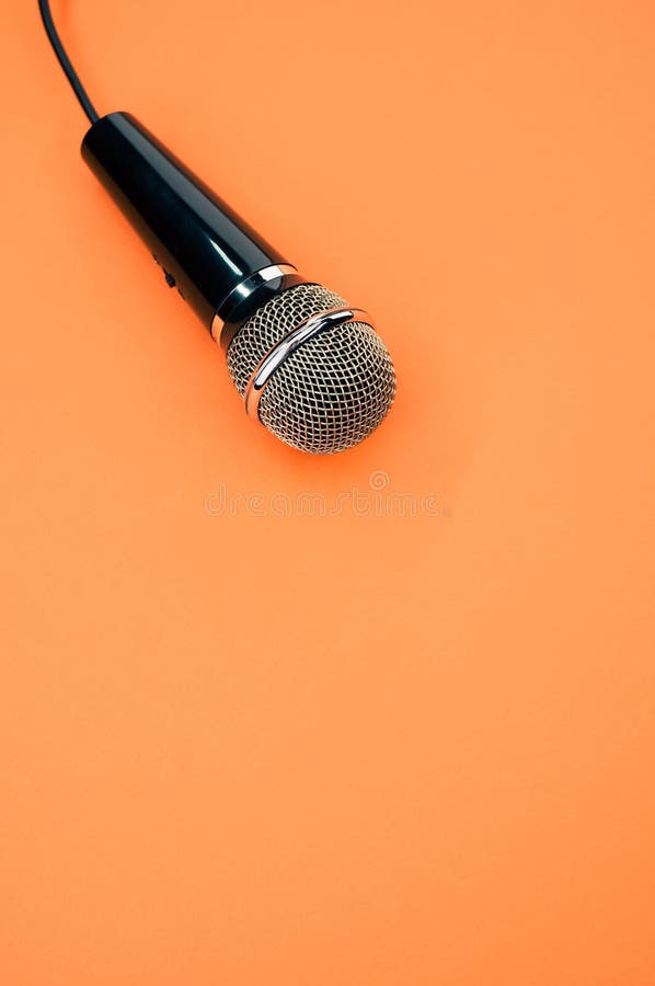 Vertical Shot of a Microphone on an Orange Surface Stock Photo - Image ...