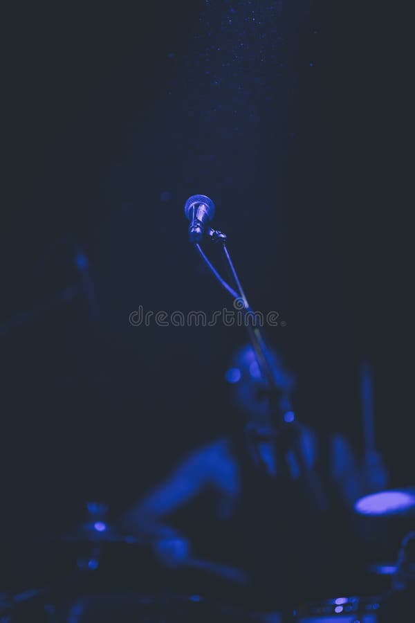 Vertical Shot of a Microphone Under a Blue Spotlight at a Concert Stock ...