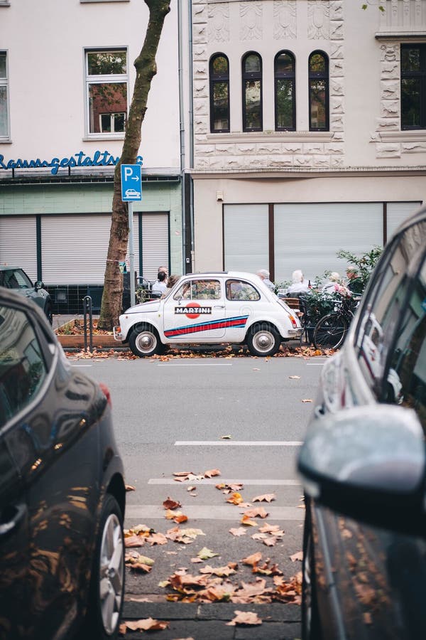 A Vertical Shot of a Mini Cooper with Martini Advertising on the Road ...