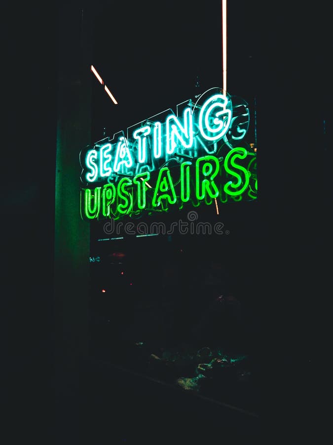 Vertical Shot of a Modern Sign with Neon Lights and " Seating Upstairs ...