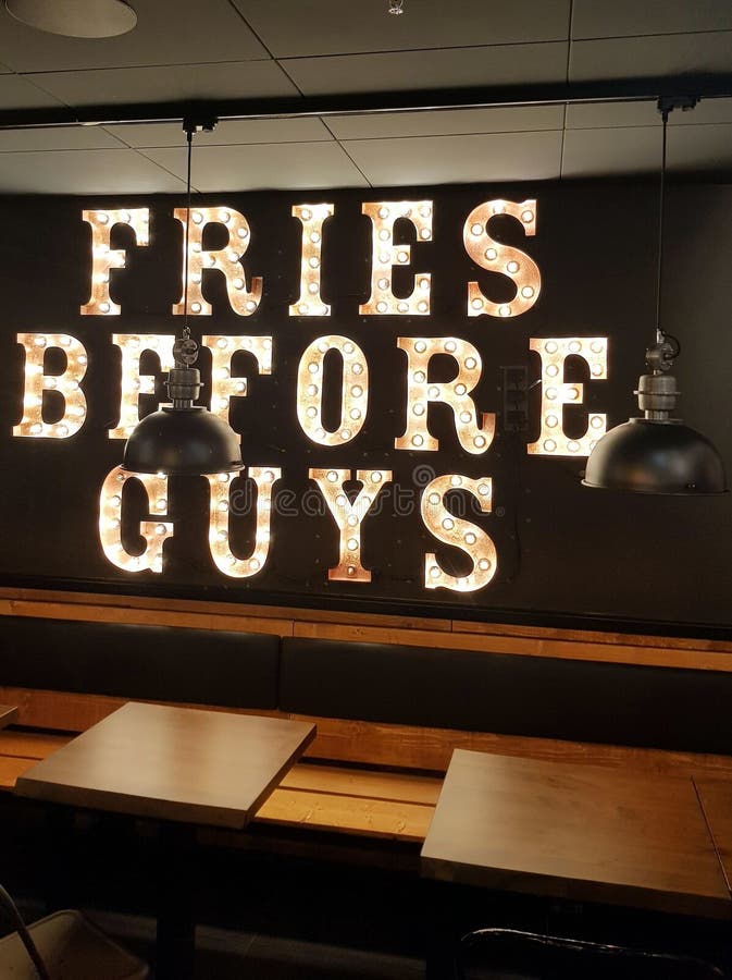 Vertical Shot of Modern Writing with Light Bulbs on a Restaurant Wall ...