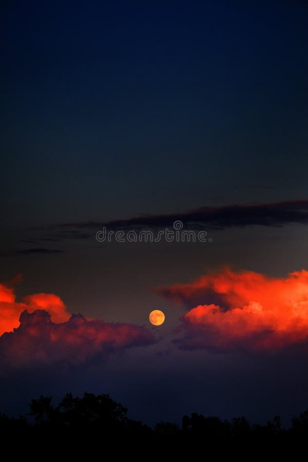 Vertical Shot of the Moon and Fire Clouds in the Dark Sky Stock Image ...