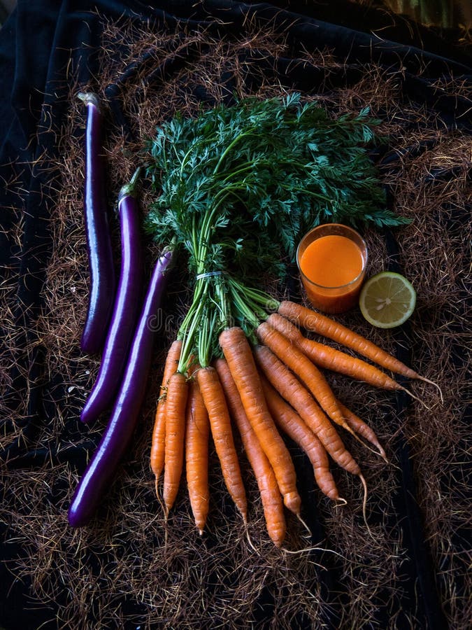 Vertical Shot of Multiple Carrots and Eggplants Placed on Pieces of Hay ...