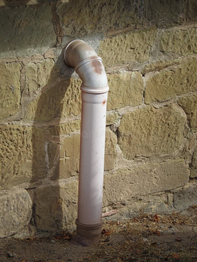 Vertical Shot of an Old Gutter Against a Stone Wall Stock Image - Image ...