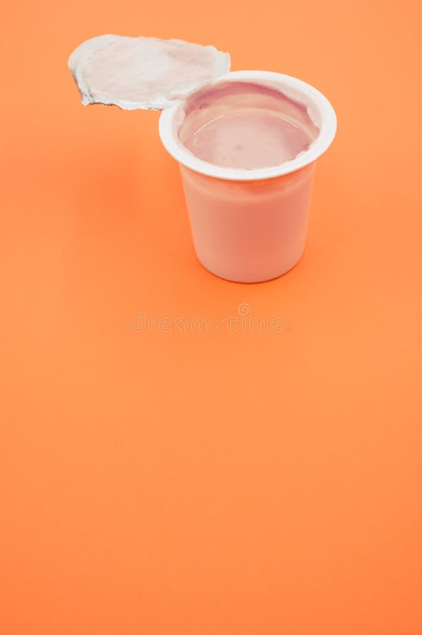 Vertical Shot of an Opened Fruit Yogurt on an Orange Surface Stock ...