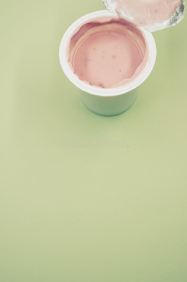 Vertical Shot of an Opened Plastic Container of Fruit Yogurt on a Green ...