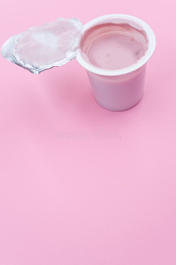 Vertical Shot of an Opened Plastic Container of Fruit Yogurt on a Pink ...