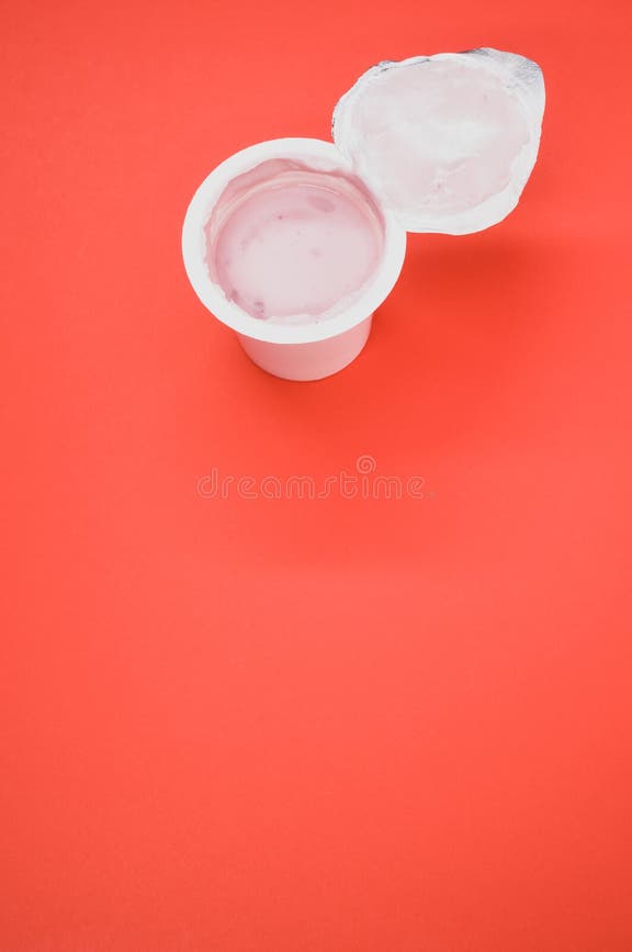 Vertical Shot of an Opened Plastic Container of Fruit Yogurt, on a Red ...