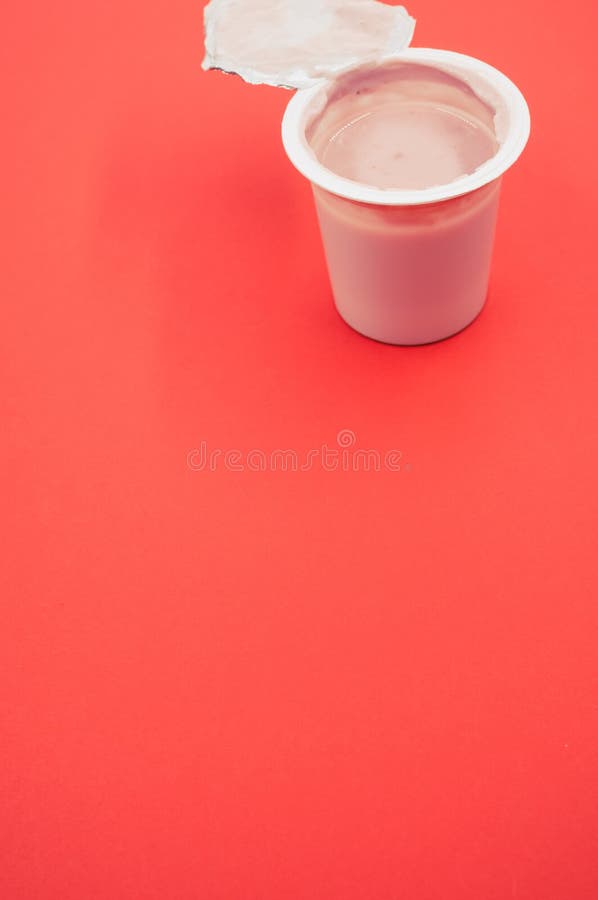 Vertical Shot of an Opened Plastic Container of Fruit Yogurt, on a Red ...