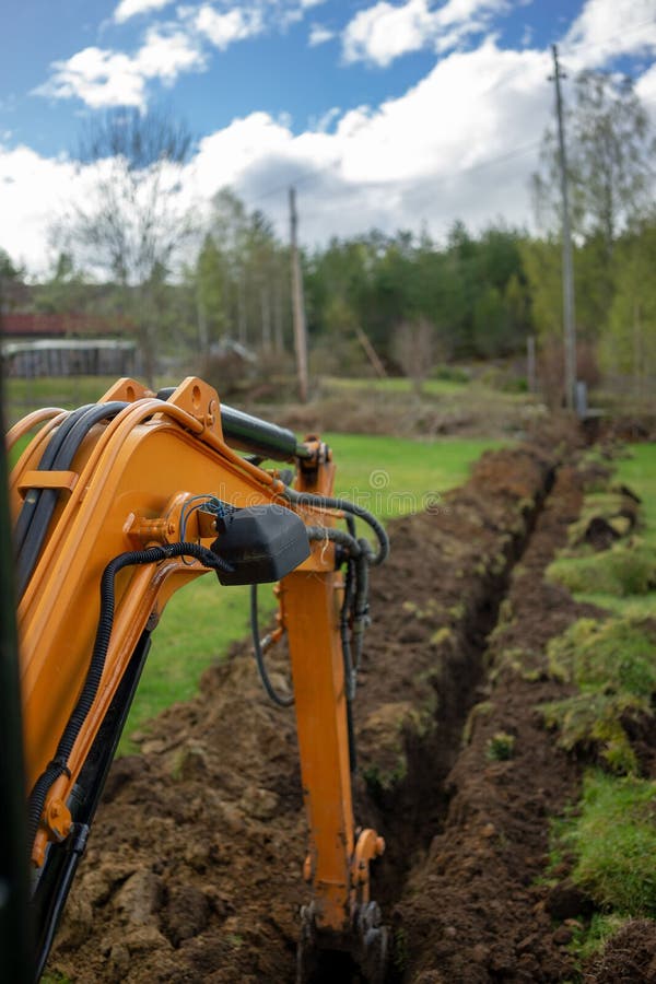 Vertical Shot of a Orange Digger Digging the Ground of the House ...
